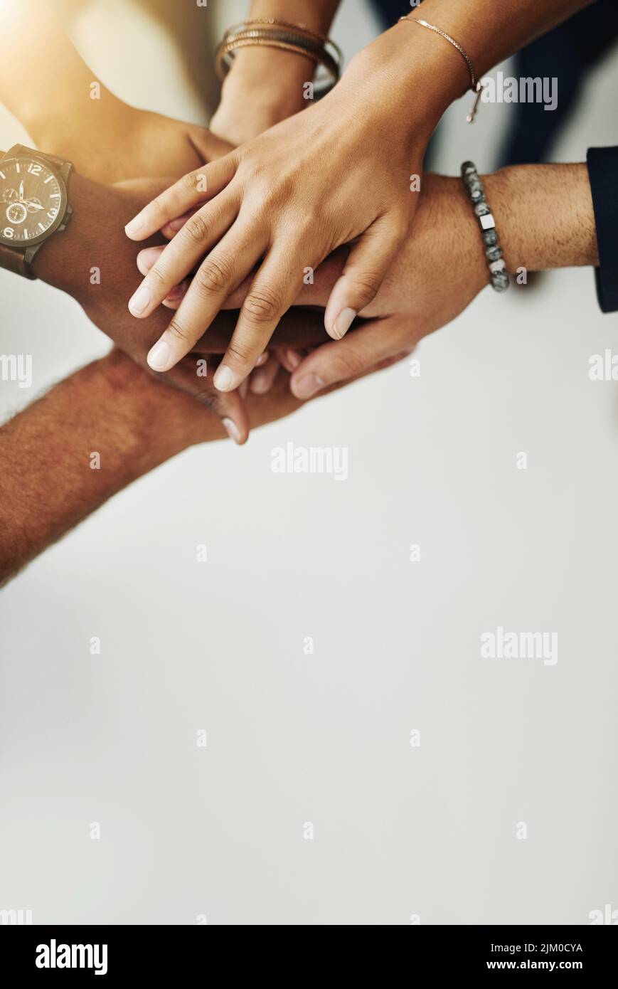 Hands in a huddle for teamwork, unity and working together from above ...