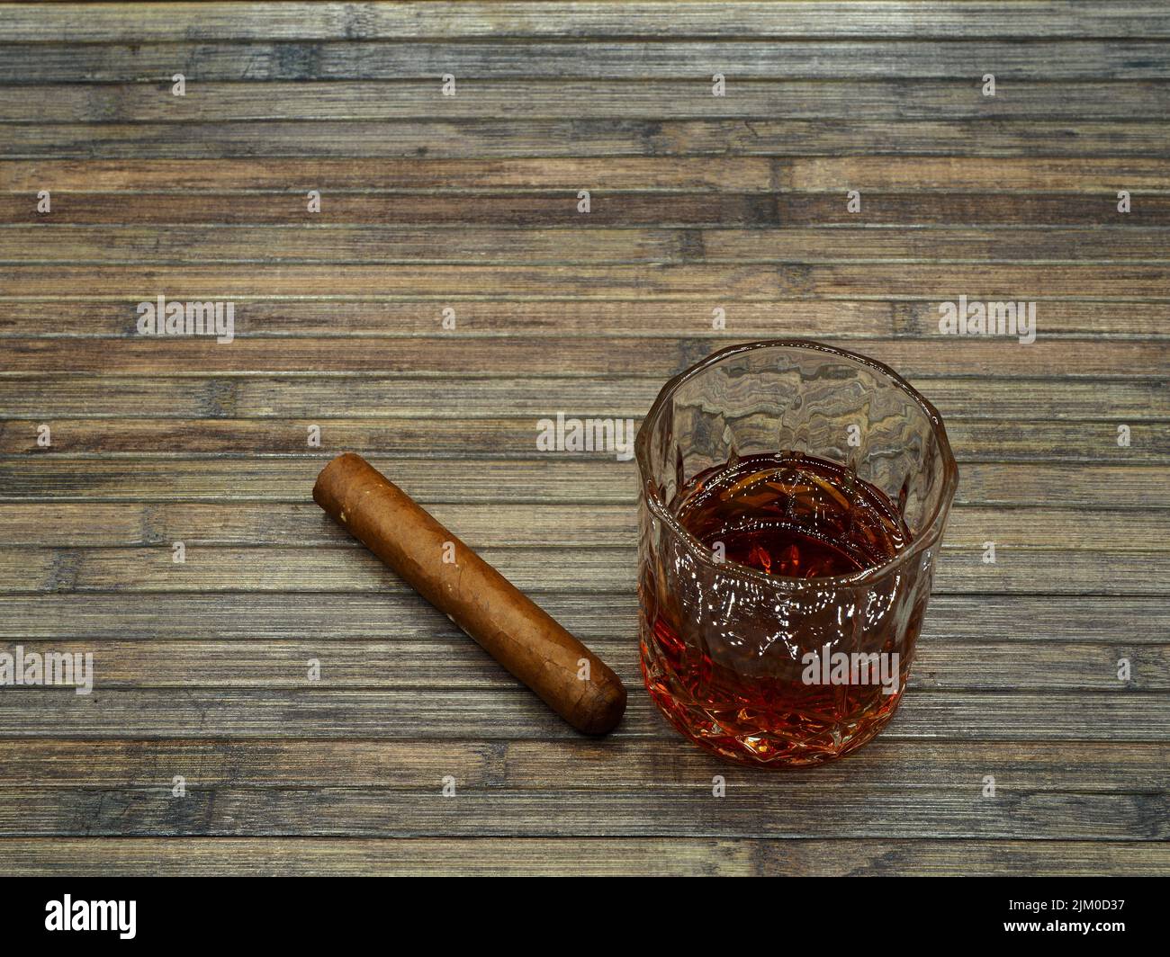 close up view of a glass of rum and an habana cigar, the perfect match ...