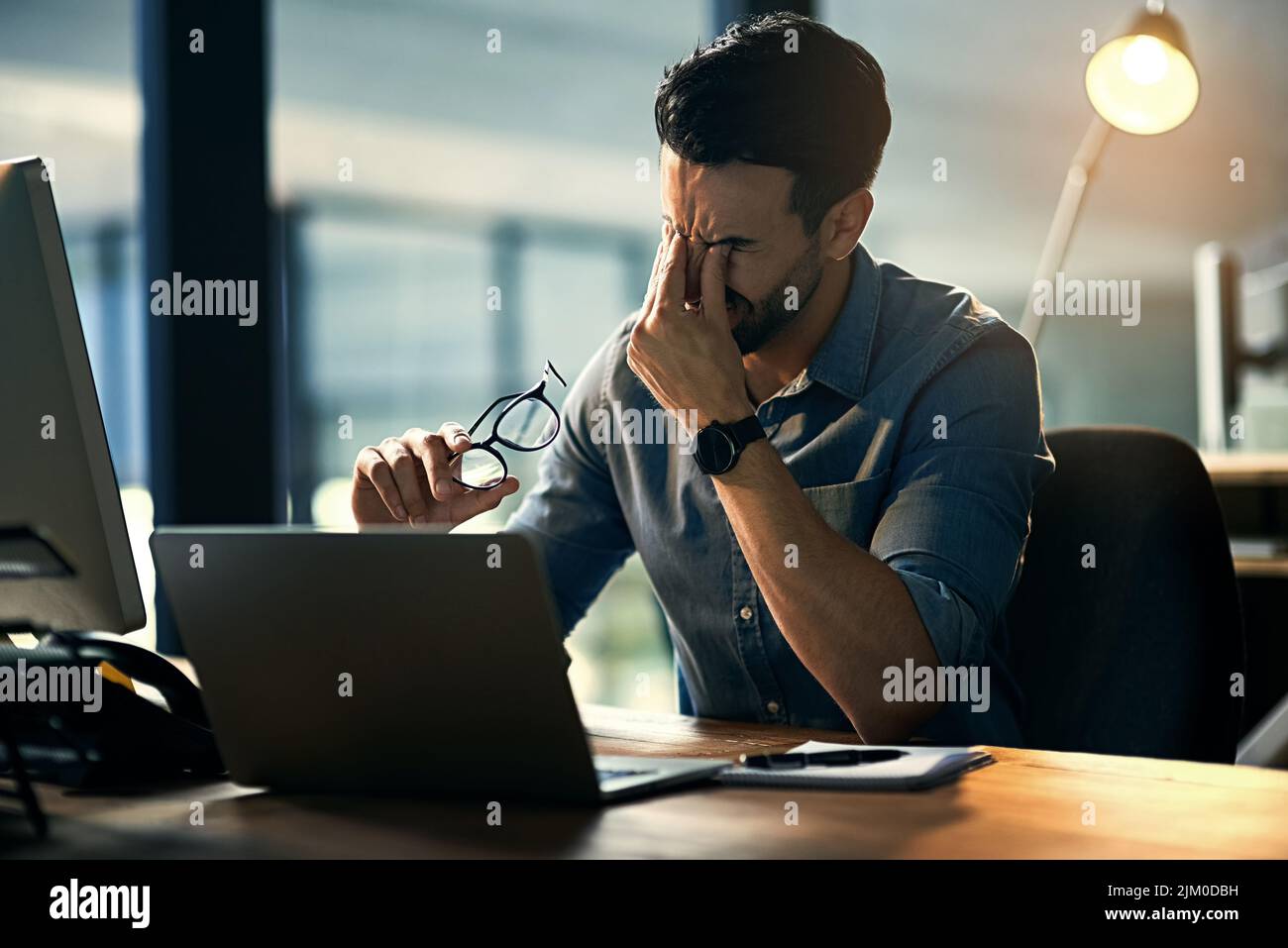 Struggling with occupational stress. Shot of a young businessman ...
