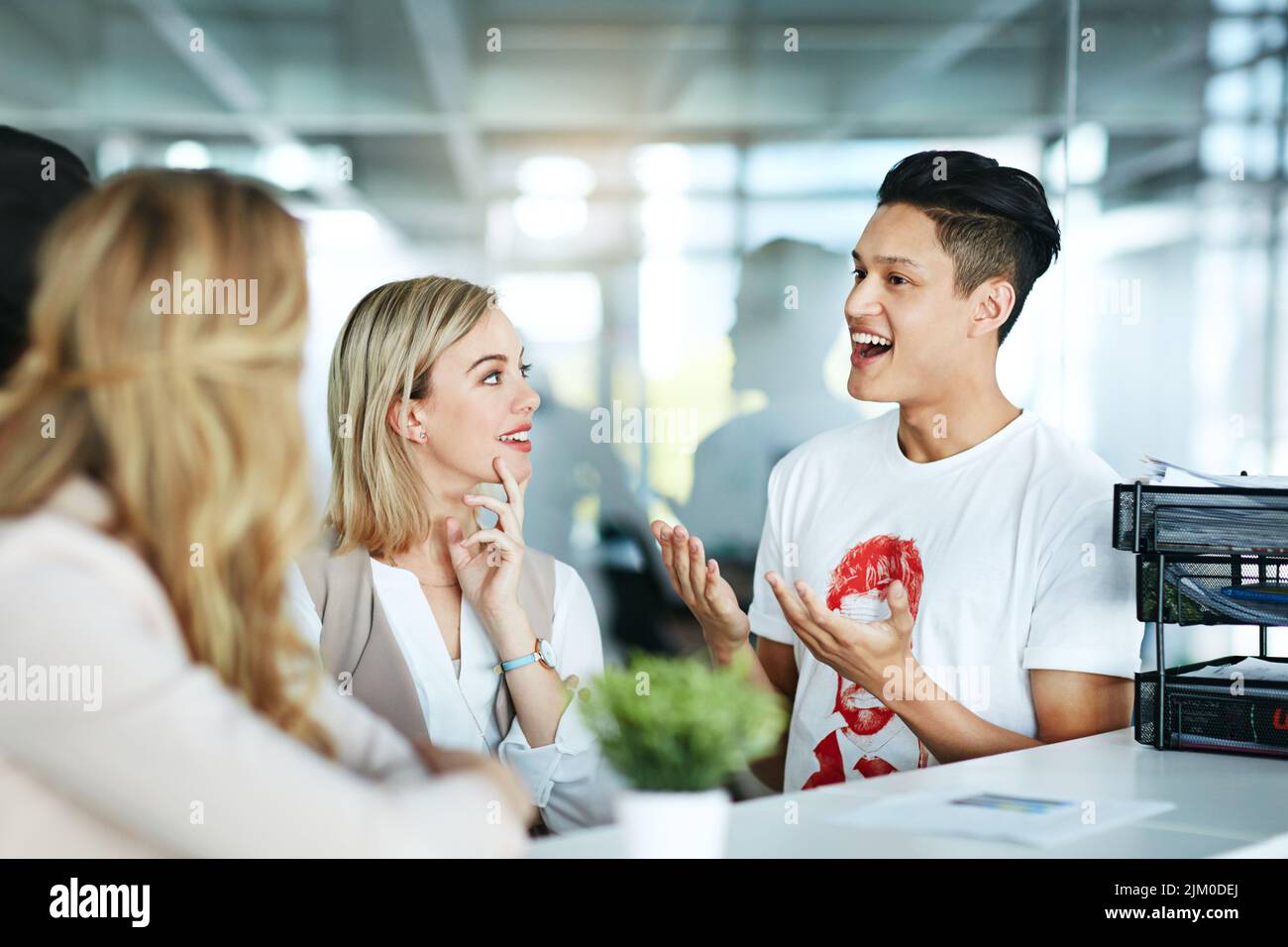 Happy and smiling design team talking while having a casual chat in a ...