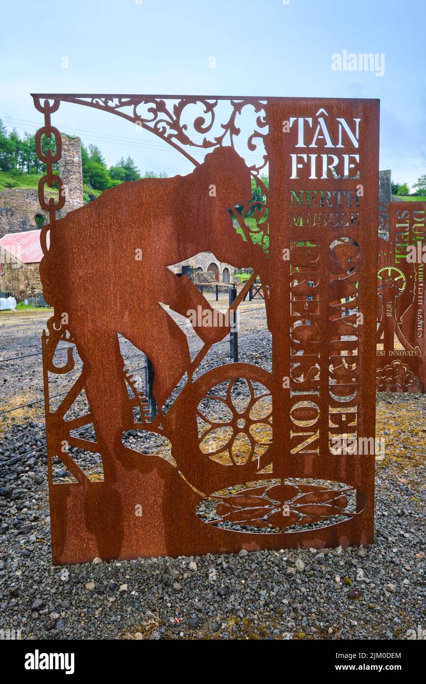 A metal, steel, rusted cutout sign, detailing Welsh text and a worker ...