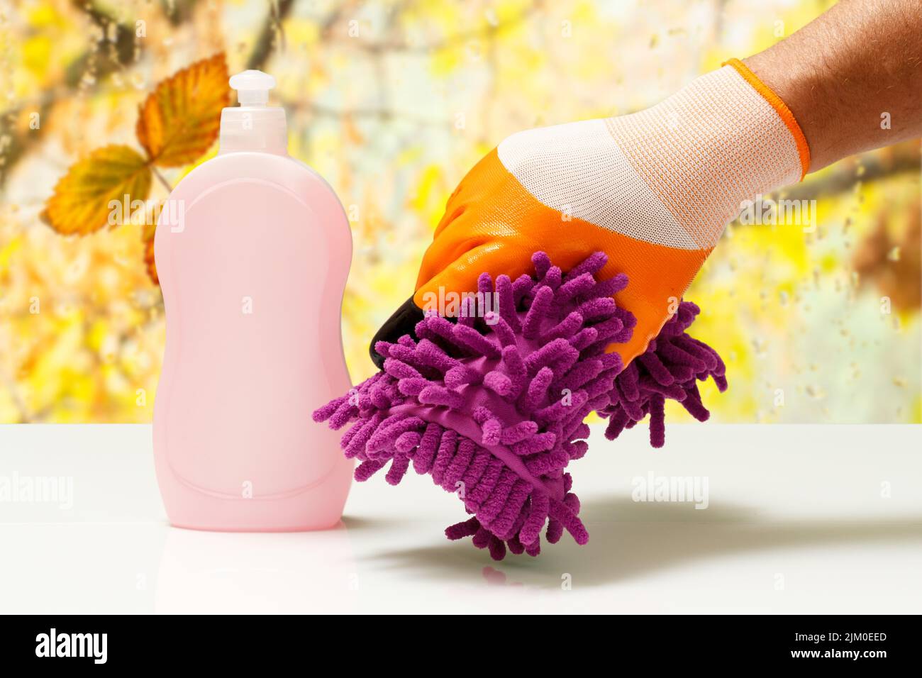 Man's hand in an orange protective glove holding the rag with the ...