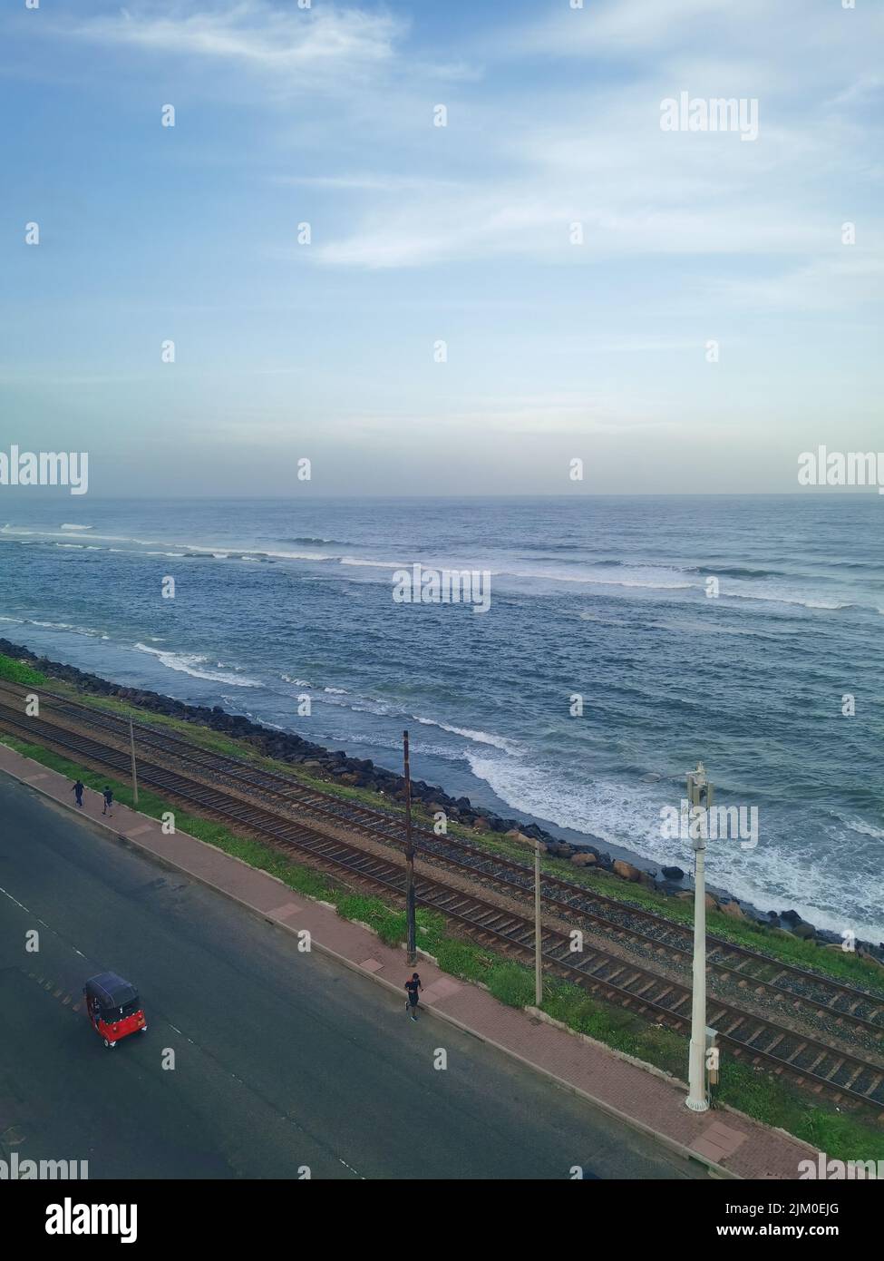 The sea, sky, road, and railway together view from above. Resembles a ...