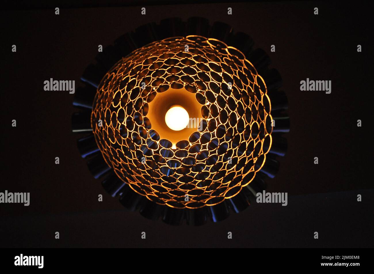 A scenic shot of a golden lamp with a lightning bulb inside in a dark ...