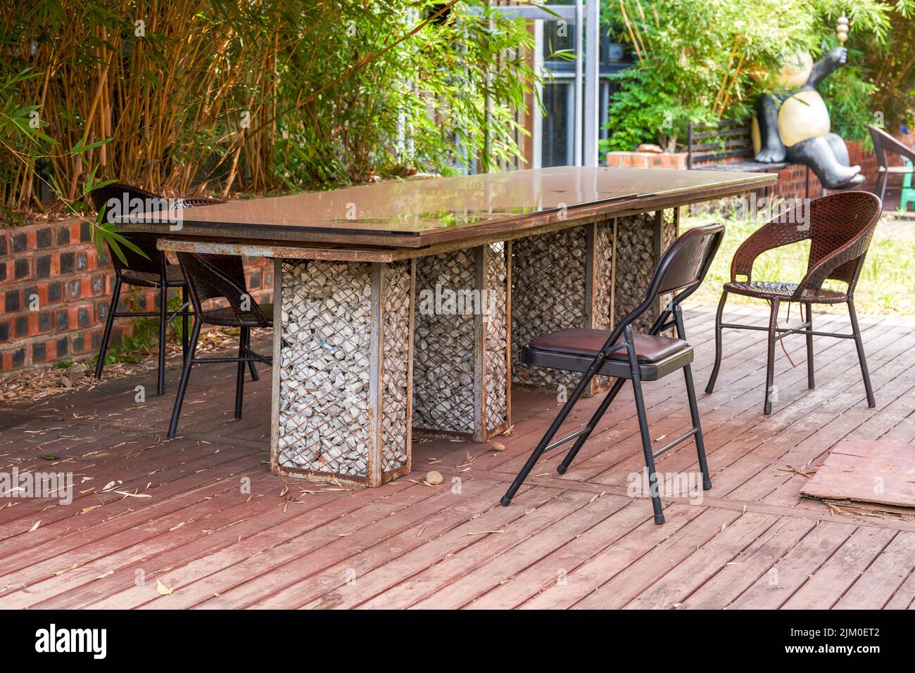 Cobblestone table with long legs in the garden Stock Photo - Alamy