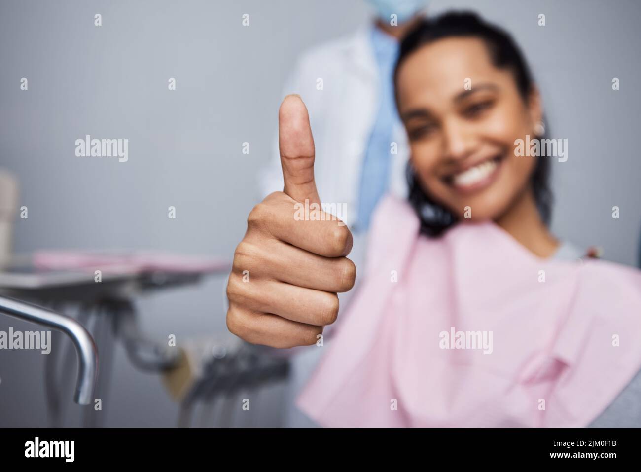 Pain free is the way for me. Portrait of a young woman showing thumbs ...