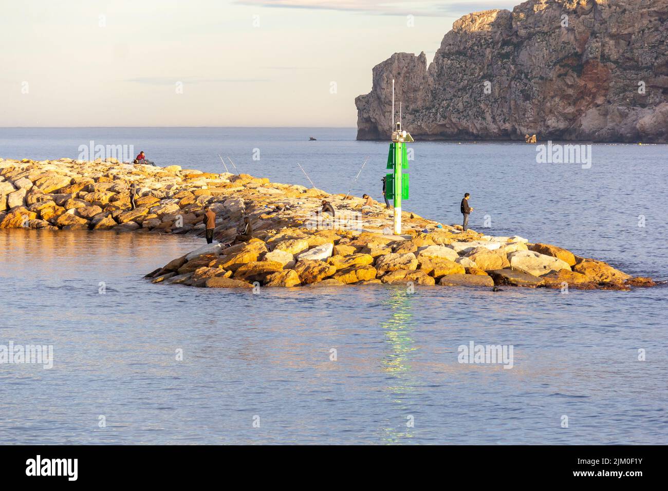 Group of people fishing on the beach breakwater with the sea Stock ...