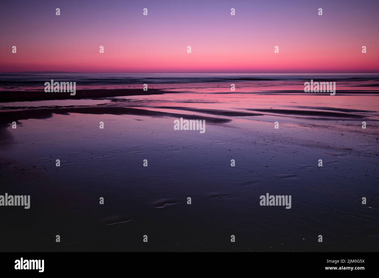 A mesmerizing scene of water by pink and blue sunset on the horizon in ...