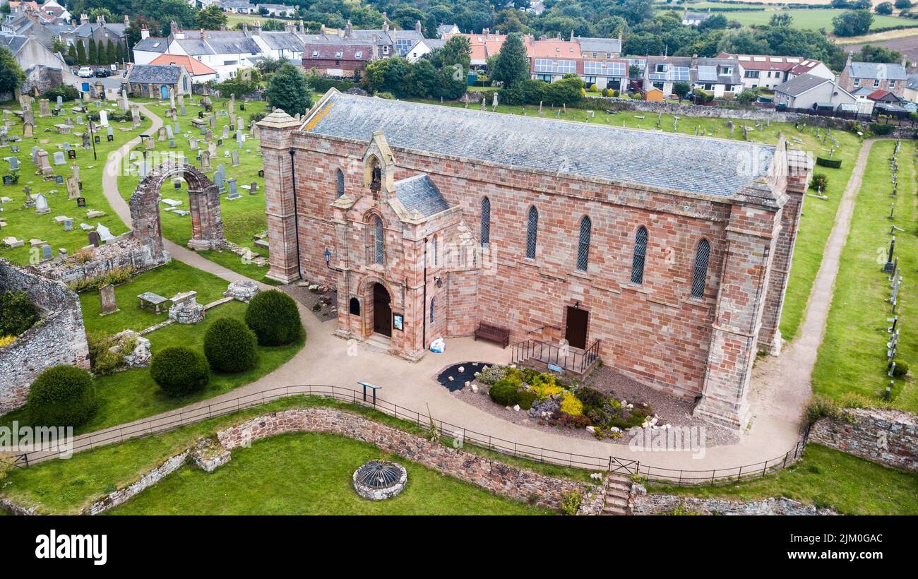 An aerial view of the Coldingham Priory church surrounded by graveyards ...