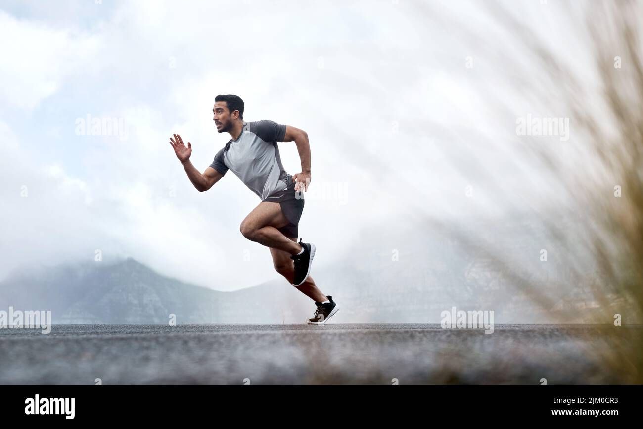 Champions know how to push through. a sporty young man running outdoors ...