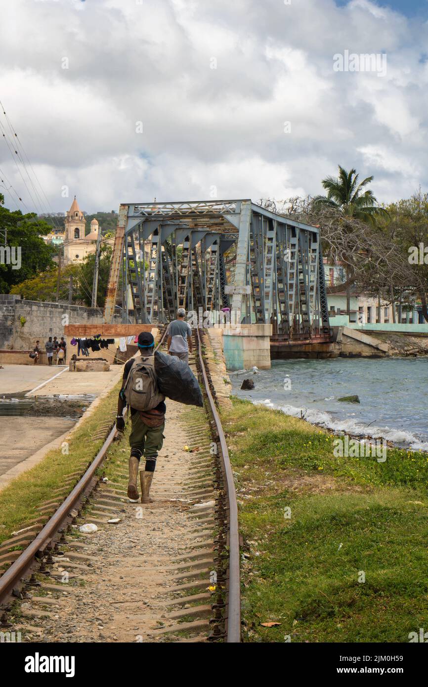 A vertical shot of some men walking on a railway track in Matanzas ...