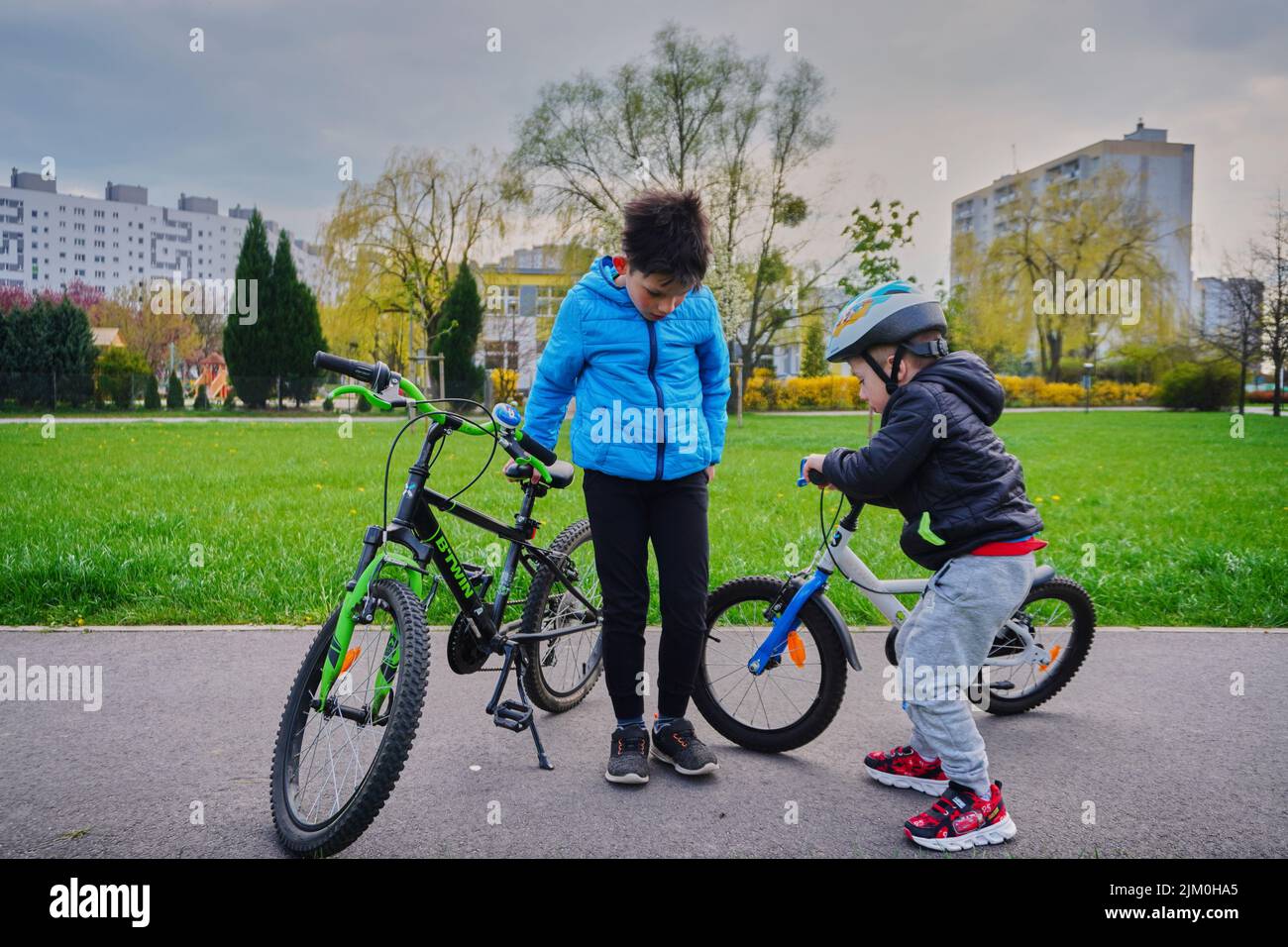 A view of two young boys with their bicycles in the garden looking for ...