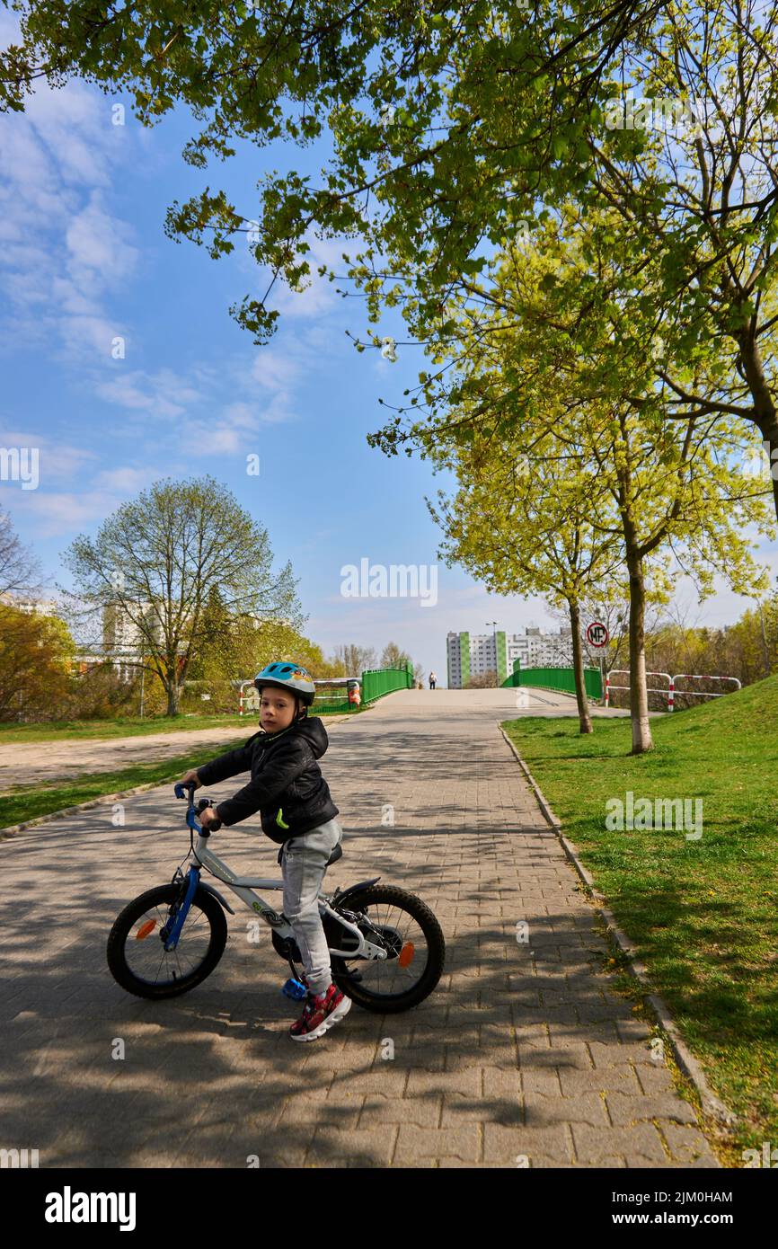 A young boy with a safety helmet sitting on a bicycle in the Stare ...