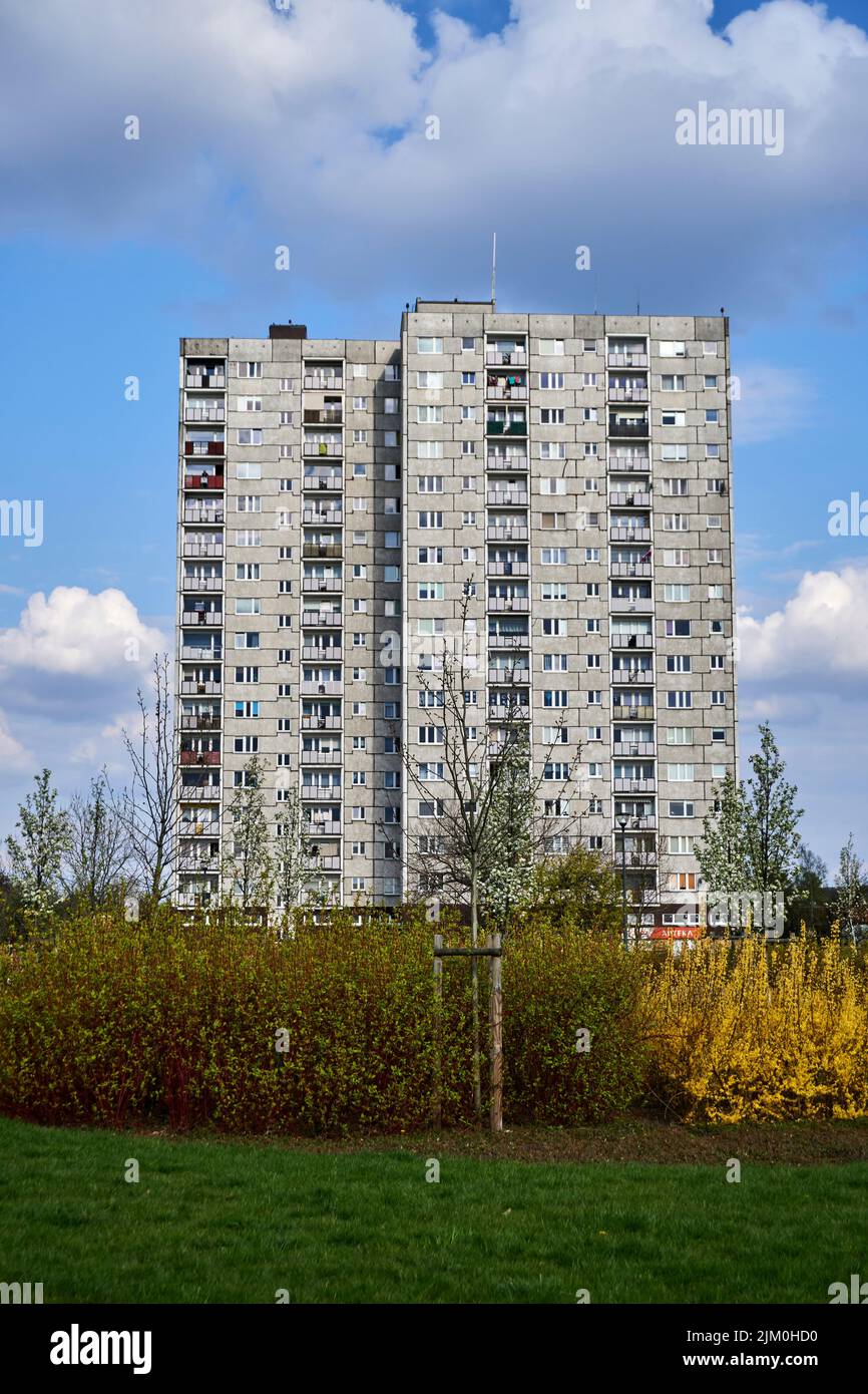 A vertical shot of tall apartment blocks near a green grass field in ...