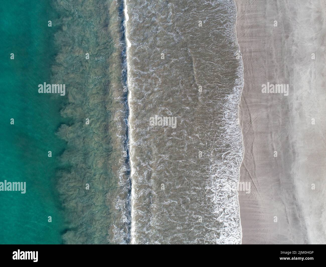 An aerial view of soft ocean waves on a sandy beach in Costa Rica Stock ...