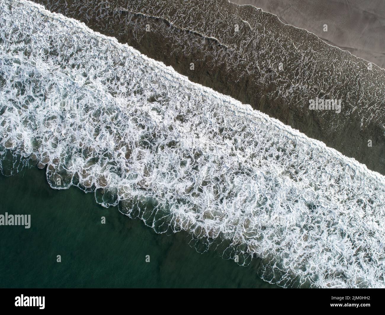 An aerial view of soft ocean waves on a sandy beach in Costa Rica Stock ...