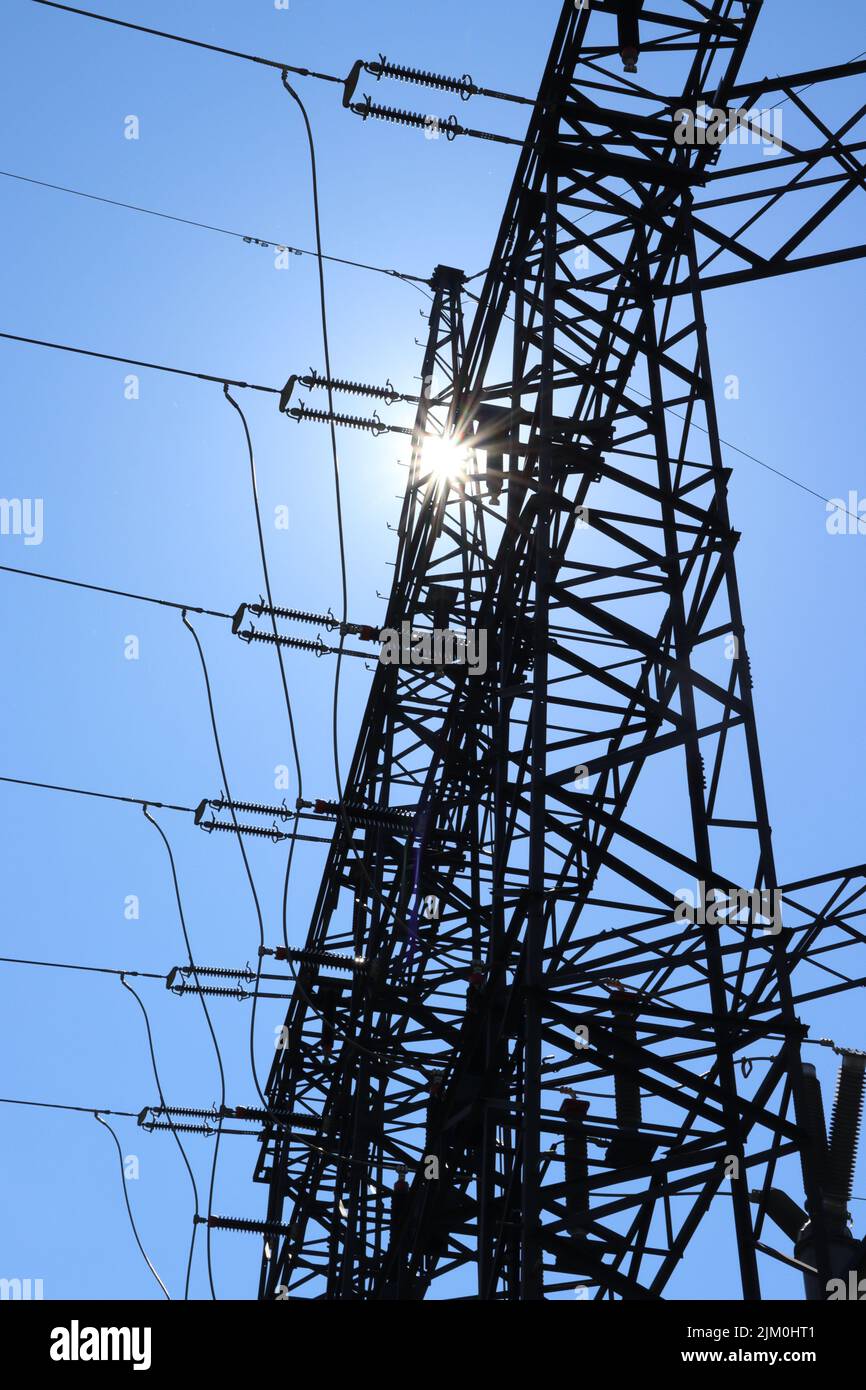 A low angle view of high-voltage power transmission towers in the sky ...