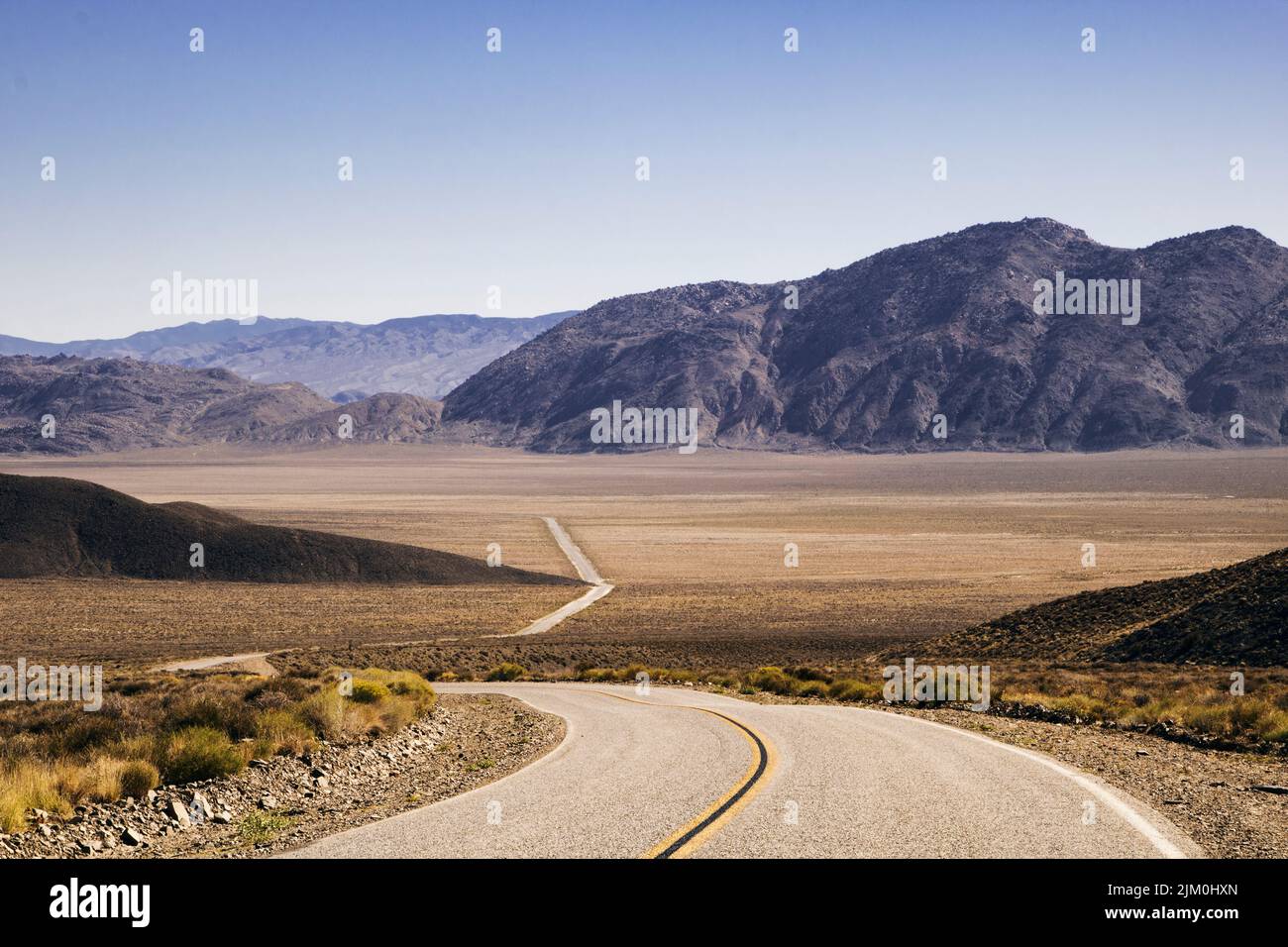 Curved road crossing a desert area in California Stock Photo - Alamy