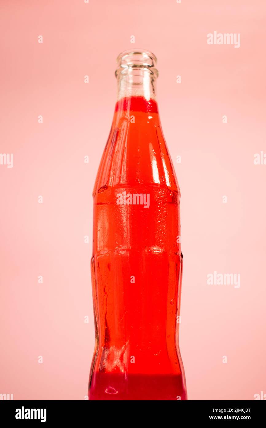 A vertical closeup of a red soda against a pink background Stock Photo ...