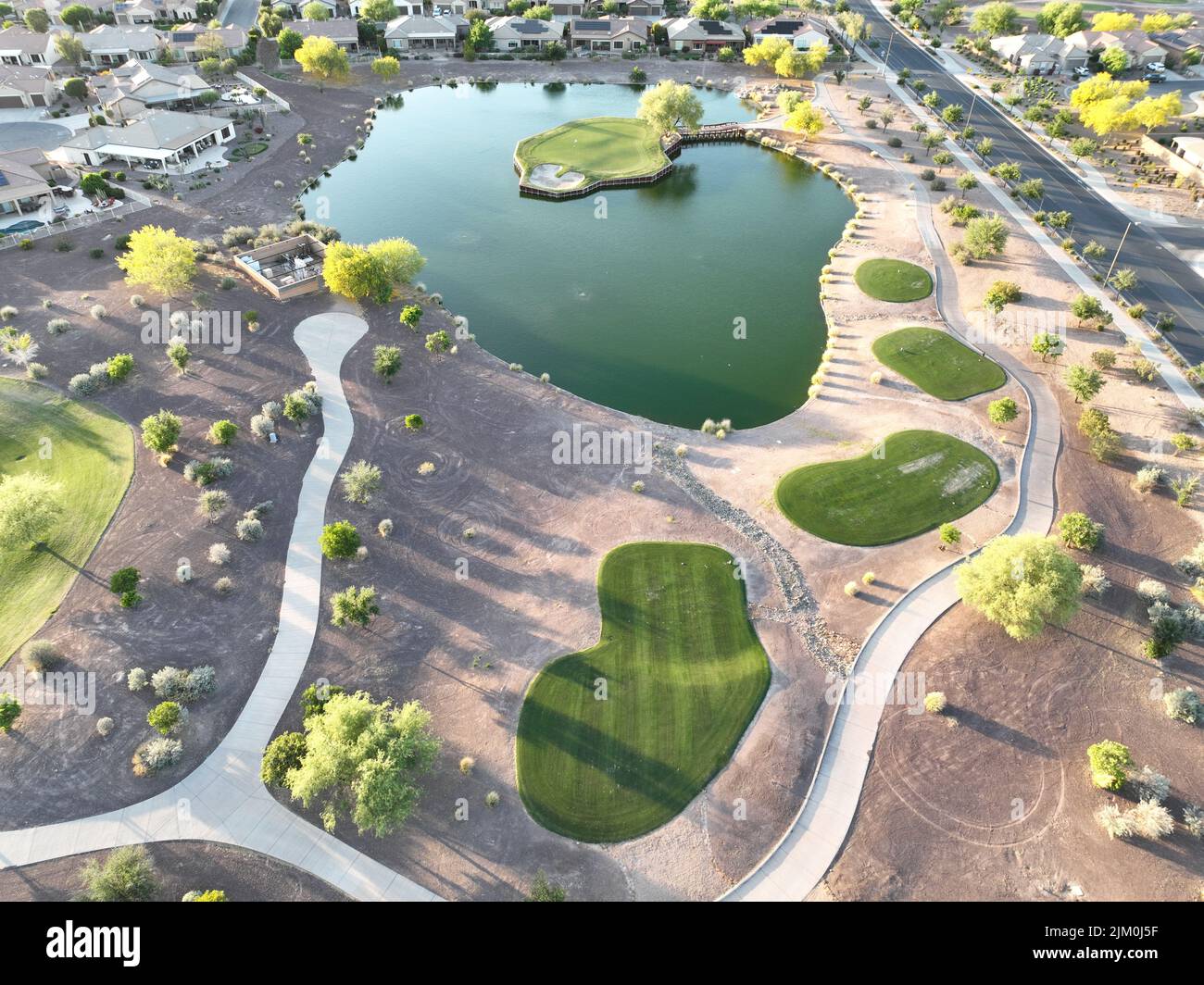 An aerial view of a beautiful park with a small pond in a town in ...