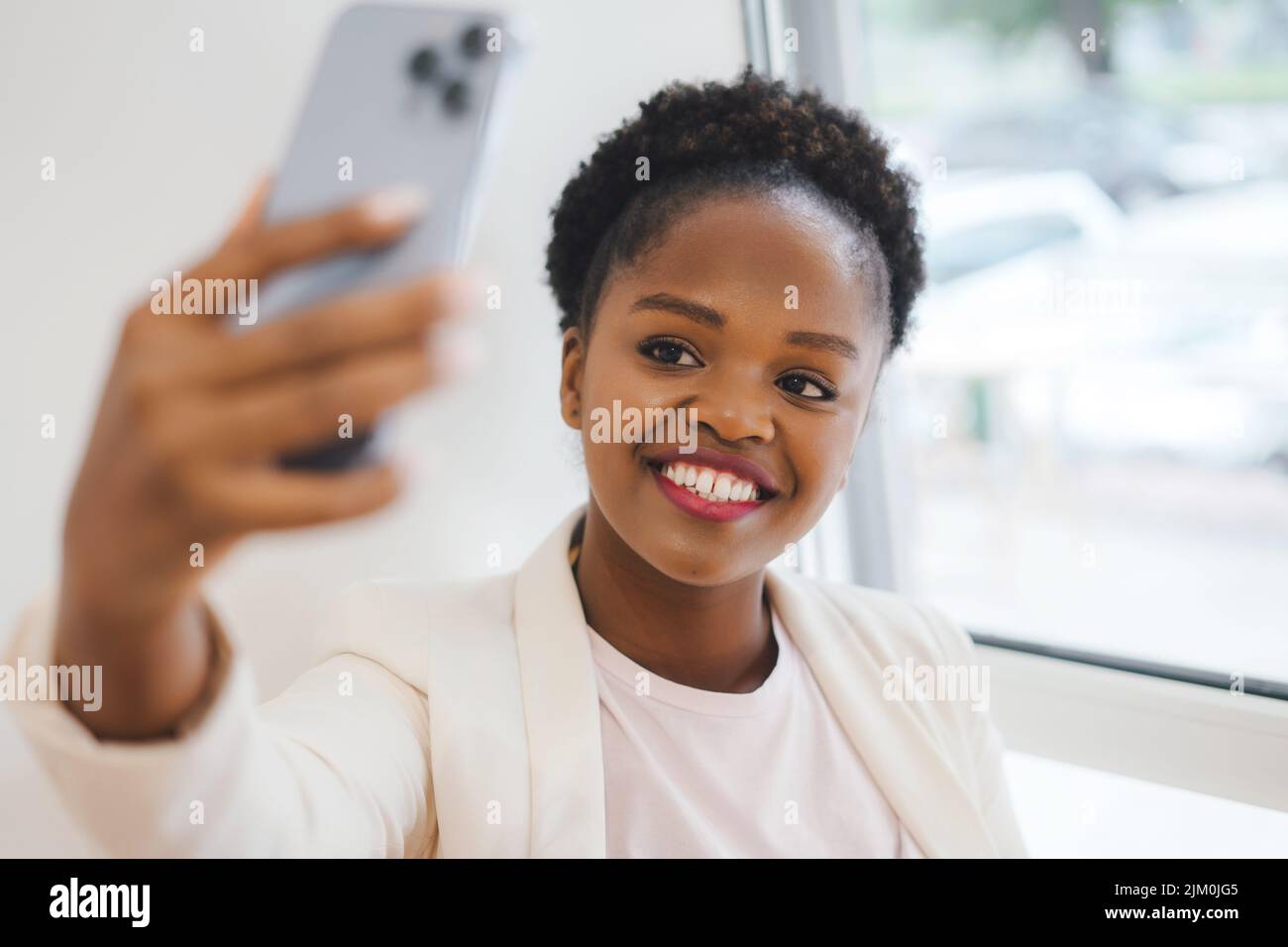 African woman starting a live video clip from her modern mobile phone ...