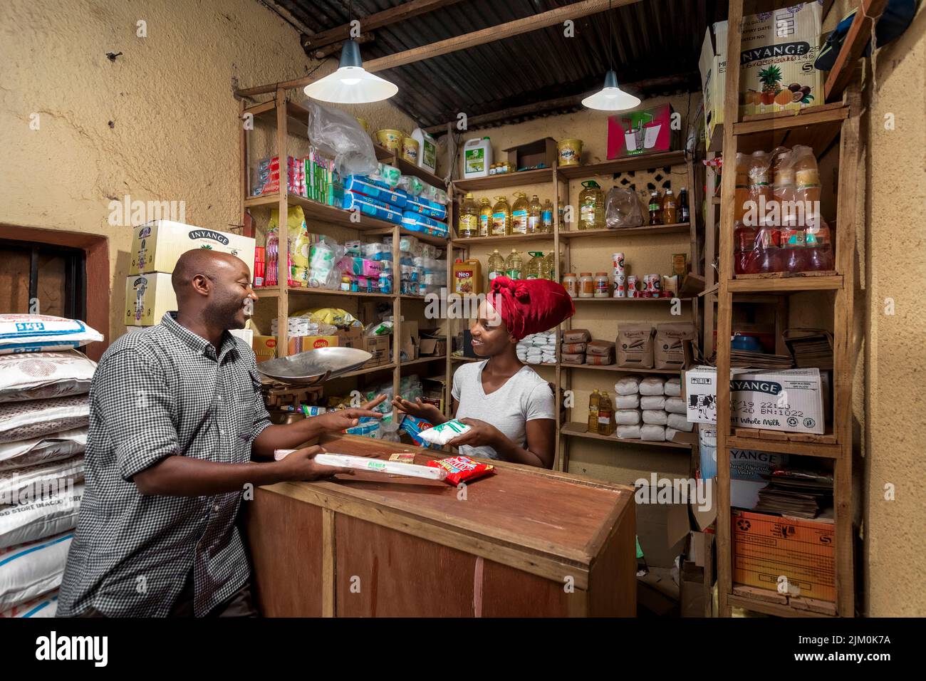 A Rwandan man talking to the cashier at a local store while shopping ...