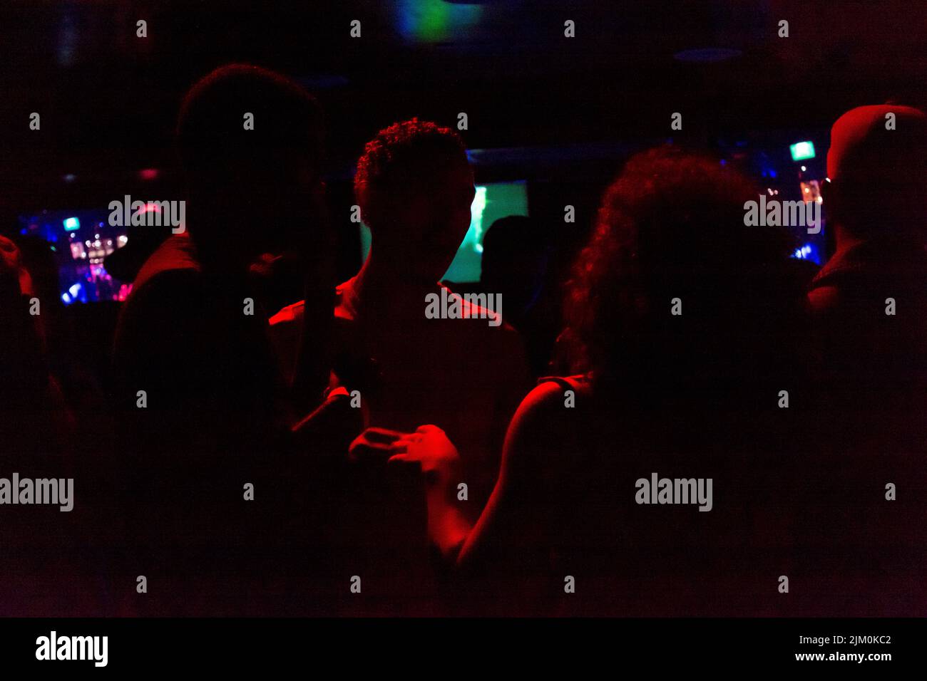 The silhouettes of people under the red light in the club Stock Photo ...