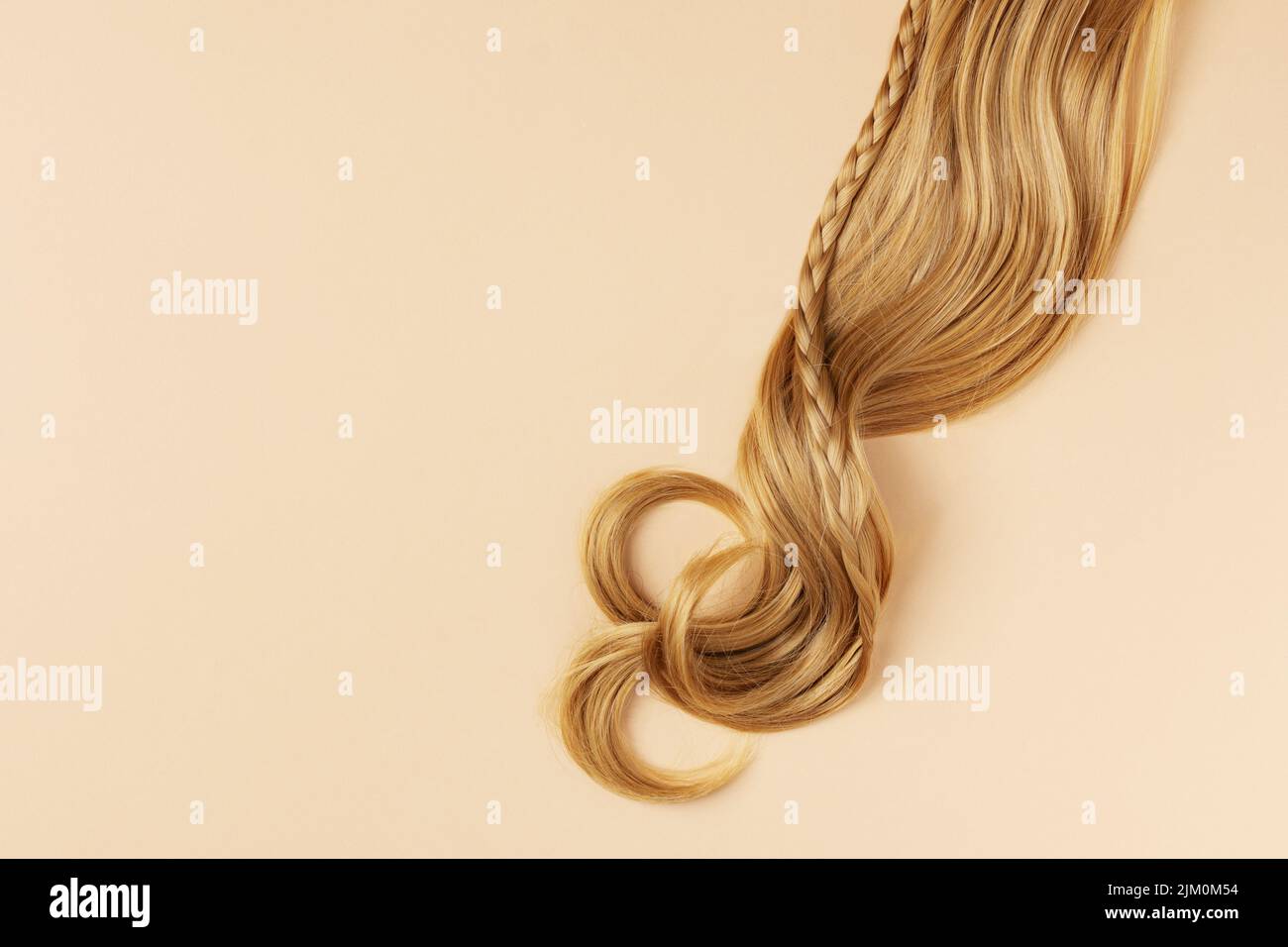 Long golden blond curly hair. A part of blond hair top view on yellow ...