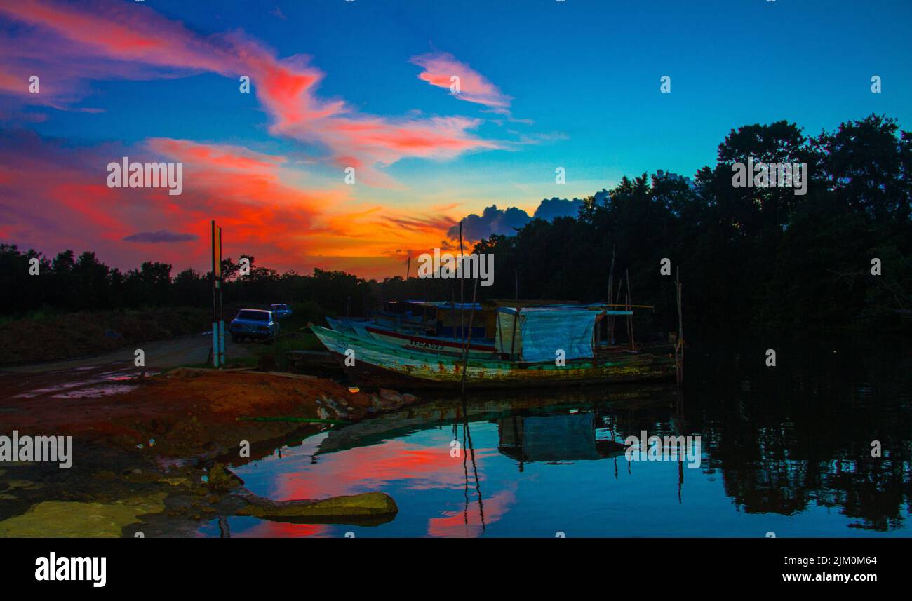 A mesmerizing colorful sunset sky over a country area with a lake Stock ...