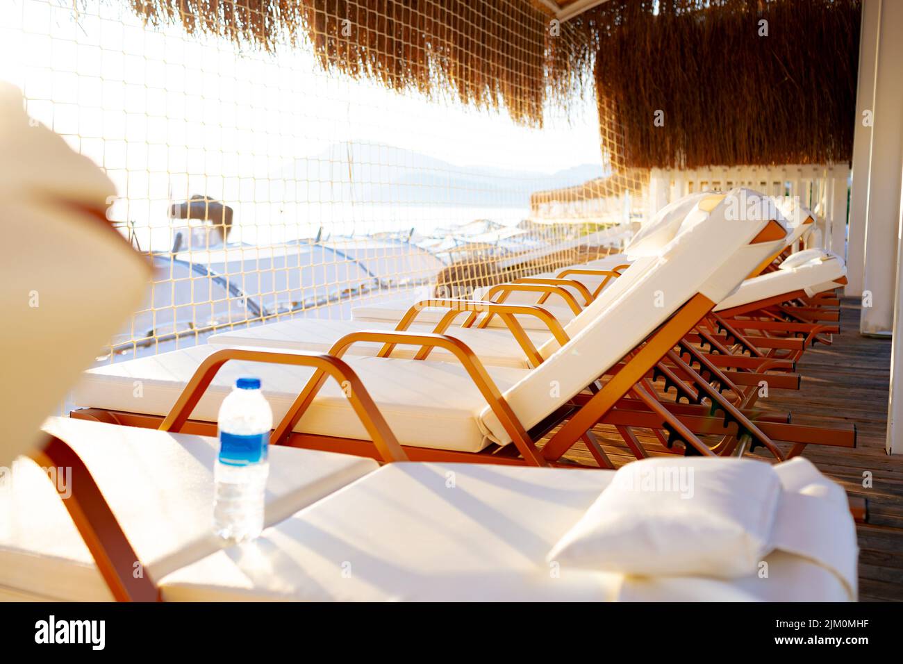 Empty deck chairs with white mattresses in resort hotel Stock Photo - Alamy