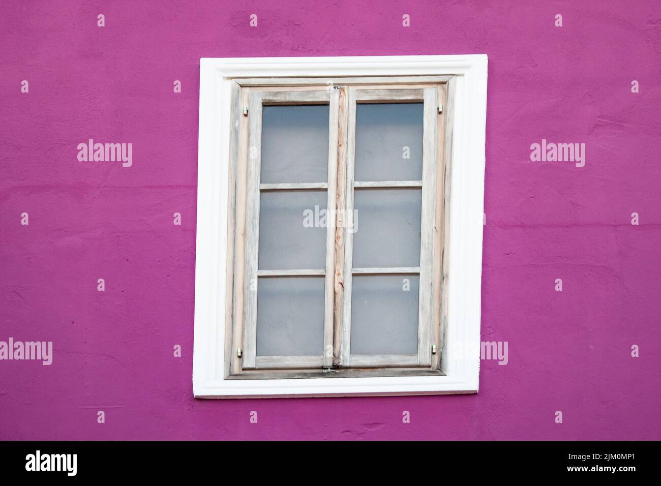 White, wooden window on pink building photographed up close Stock Photo ...
