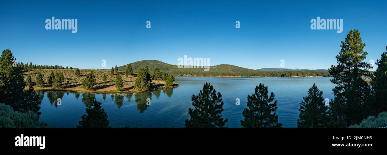 Blue lake water lays calm under a California morning sky Stock Photo ...