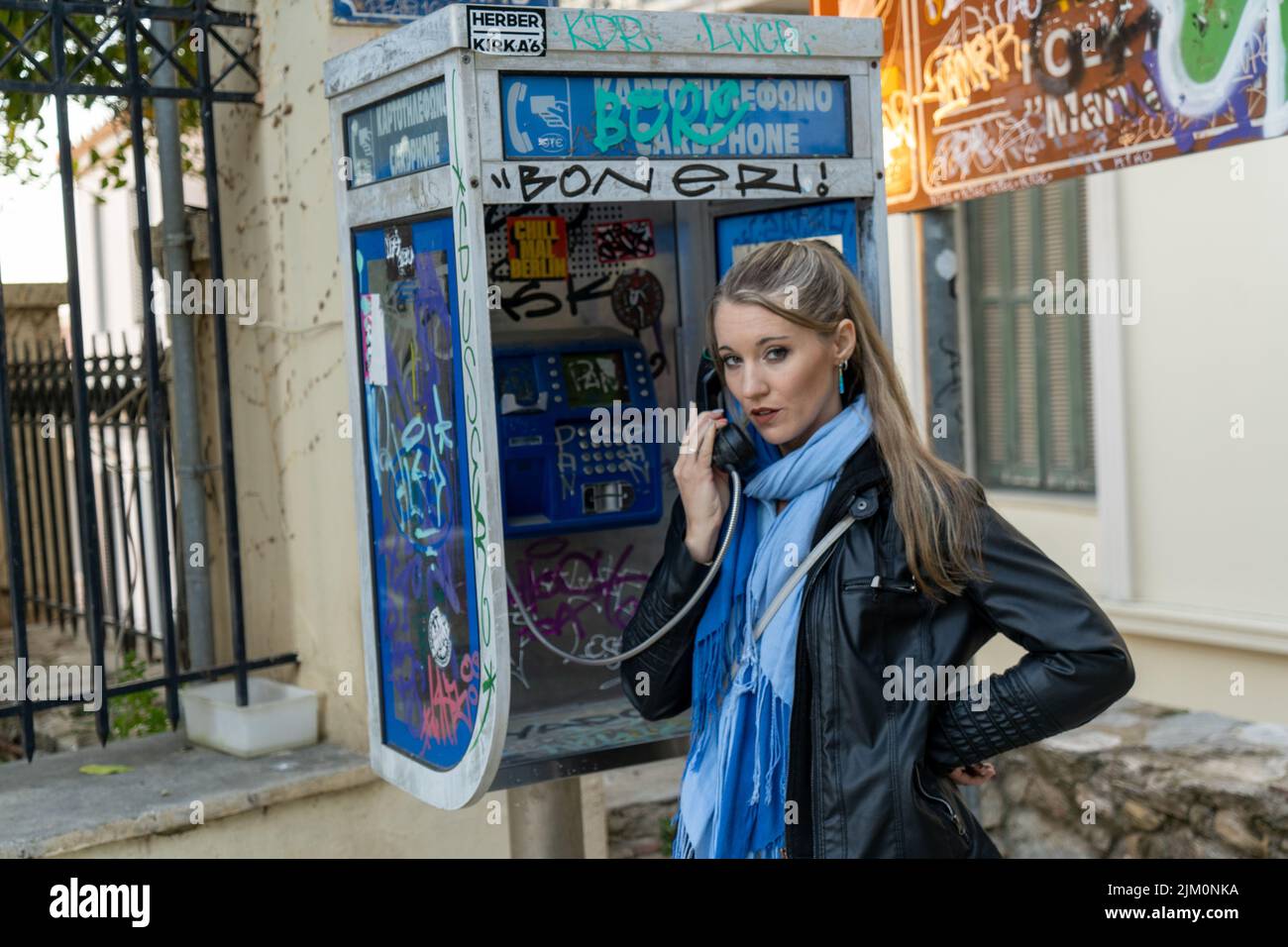 a Caucasian blonde woman talking on a payphone Stock Photo - Alamy