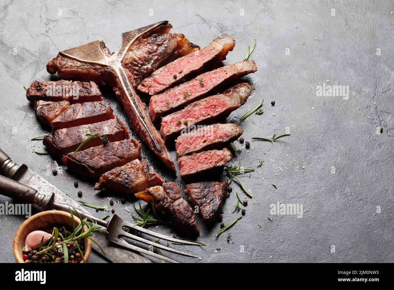 Grilled porterhouse beef steak. Sliced T-bone with herbs and spices ...