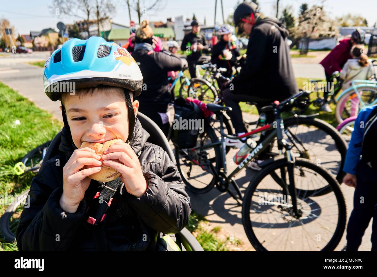 A group of active people with bicycles and eating child having a break ...
