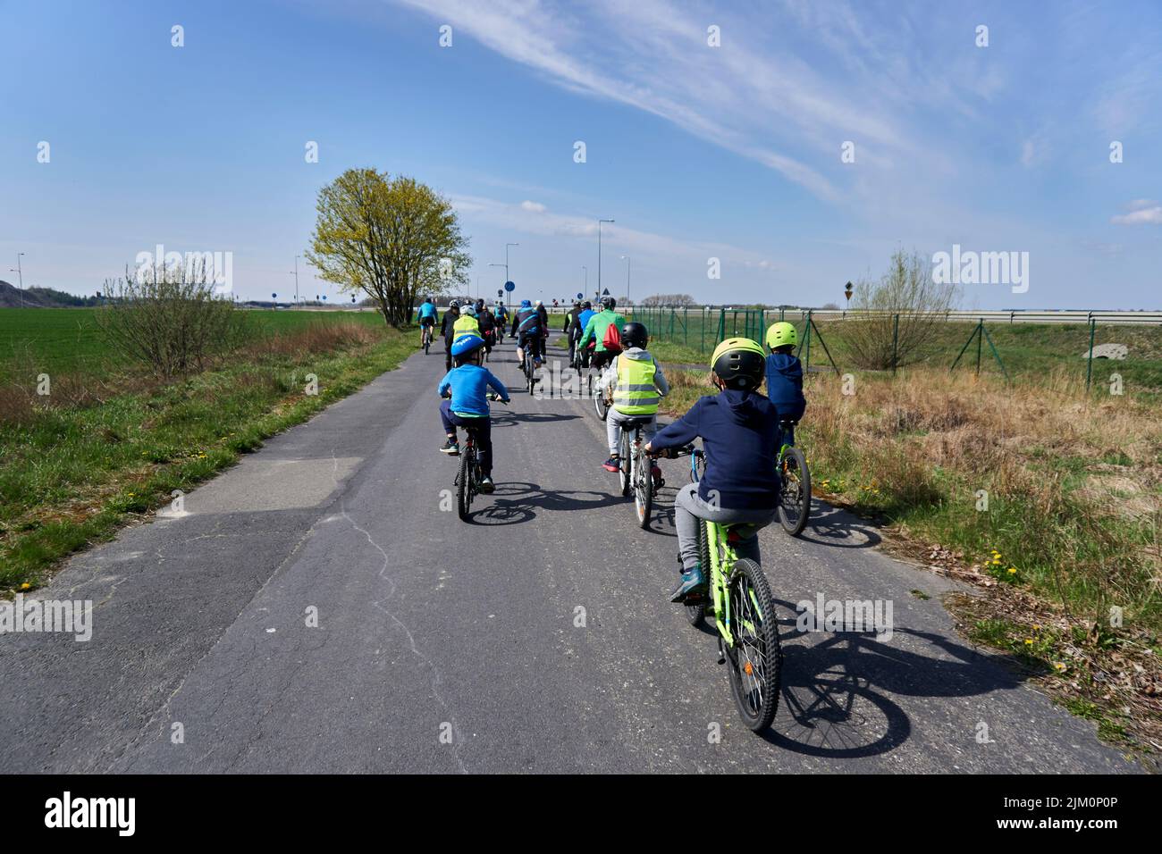 A Group of people riding bicycles on an asphalt footpath during a bike ...