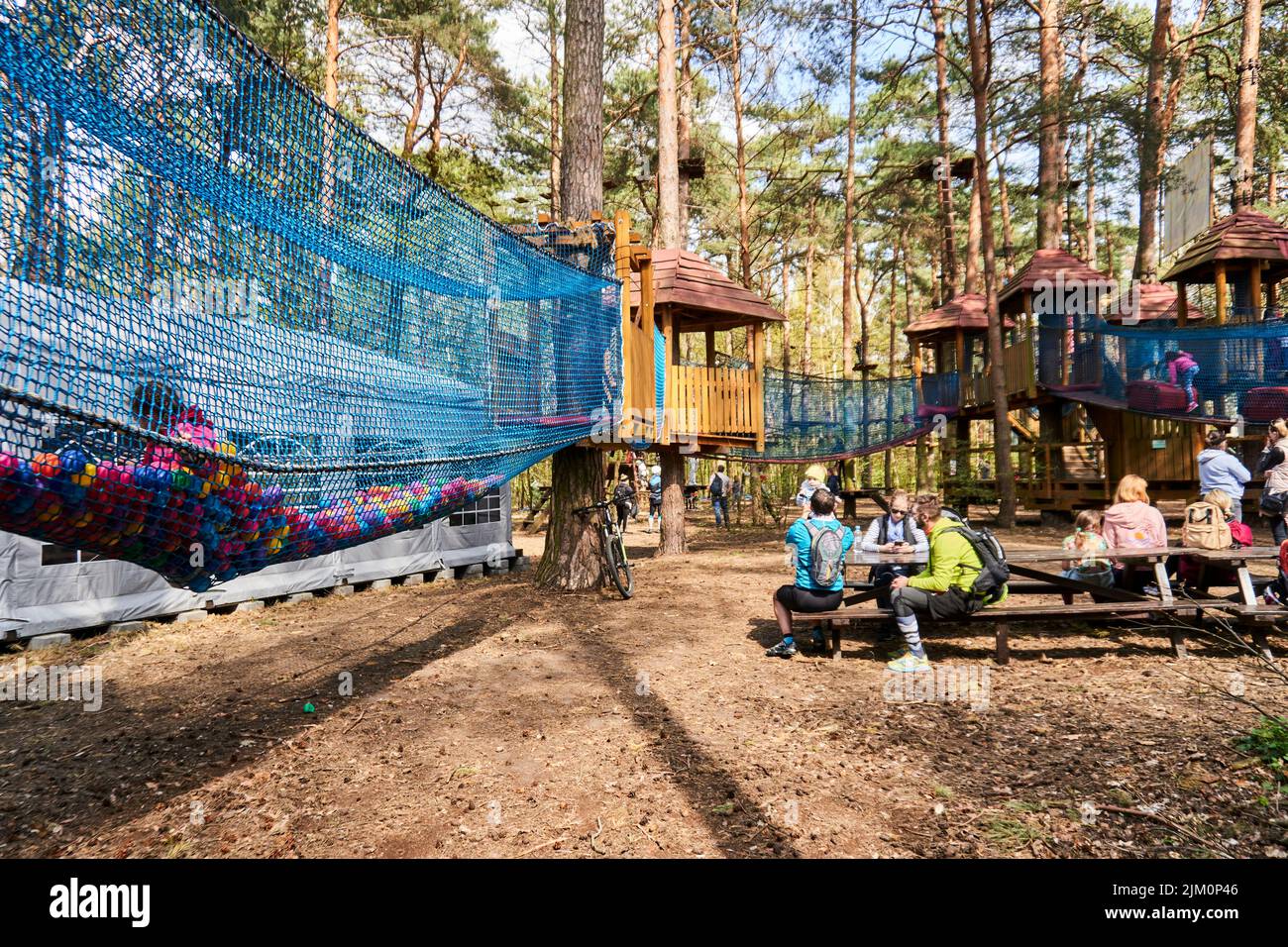 A Group of parents sitting on a wooden table and bench watching their ...