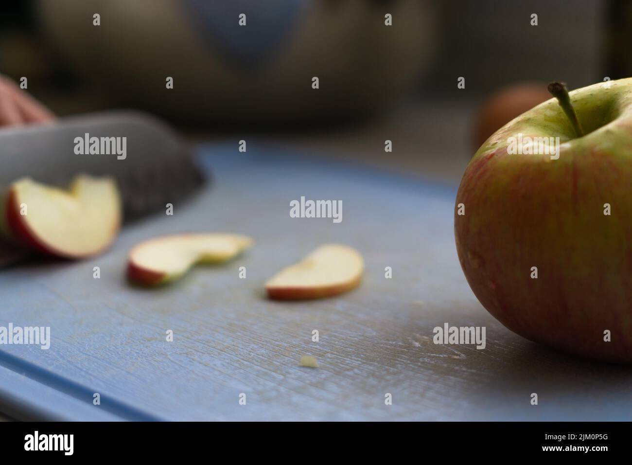 A close up slicing apple on a chopping board Stock Photo - Alamy