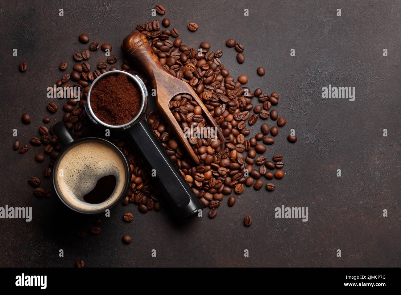 Roasted coffee beans, ground coffee in filter holder and espresso cup ...