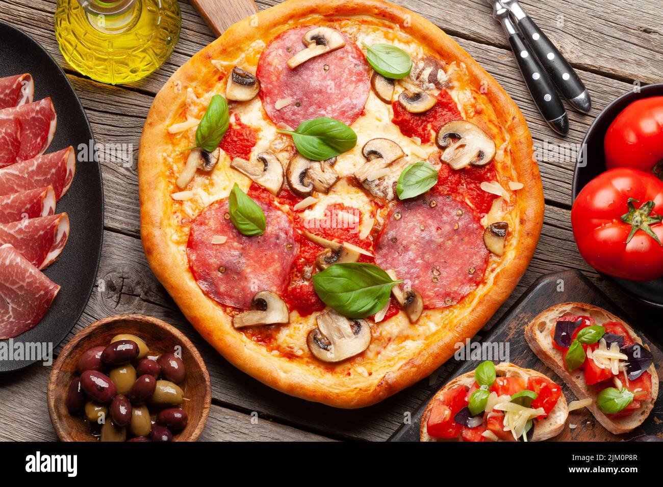 Italian cuisine. Pepperoni pizza, olives and antipasto toasts. Flat lay ...