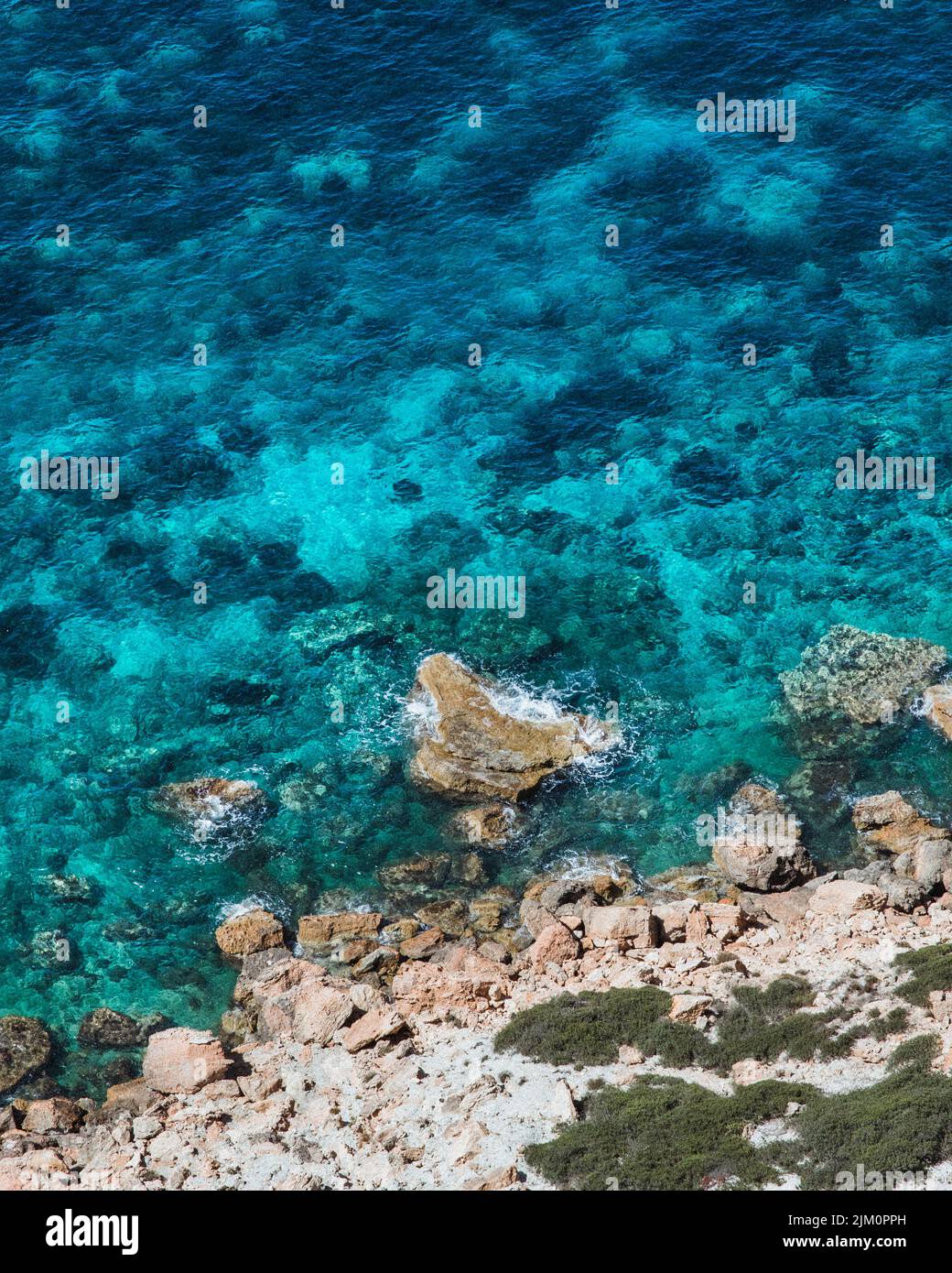 A vertical high angle shot of the vibrant clear blue waters at the ...