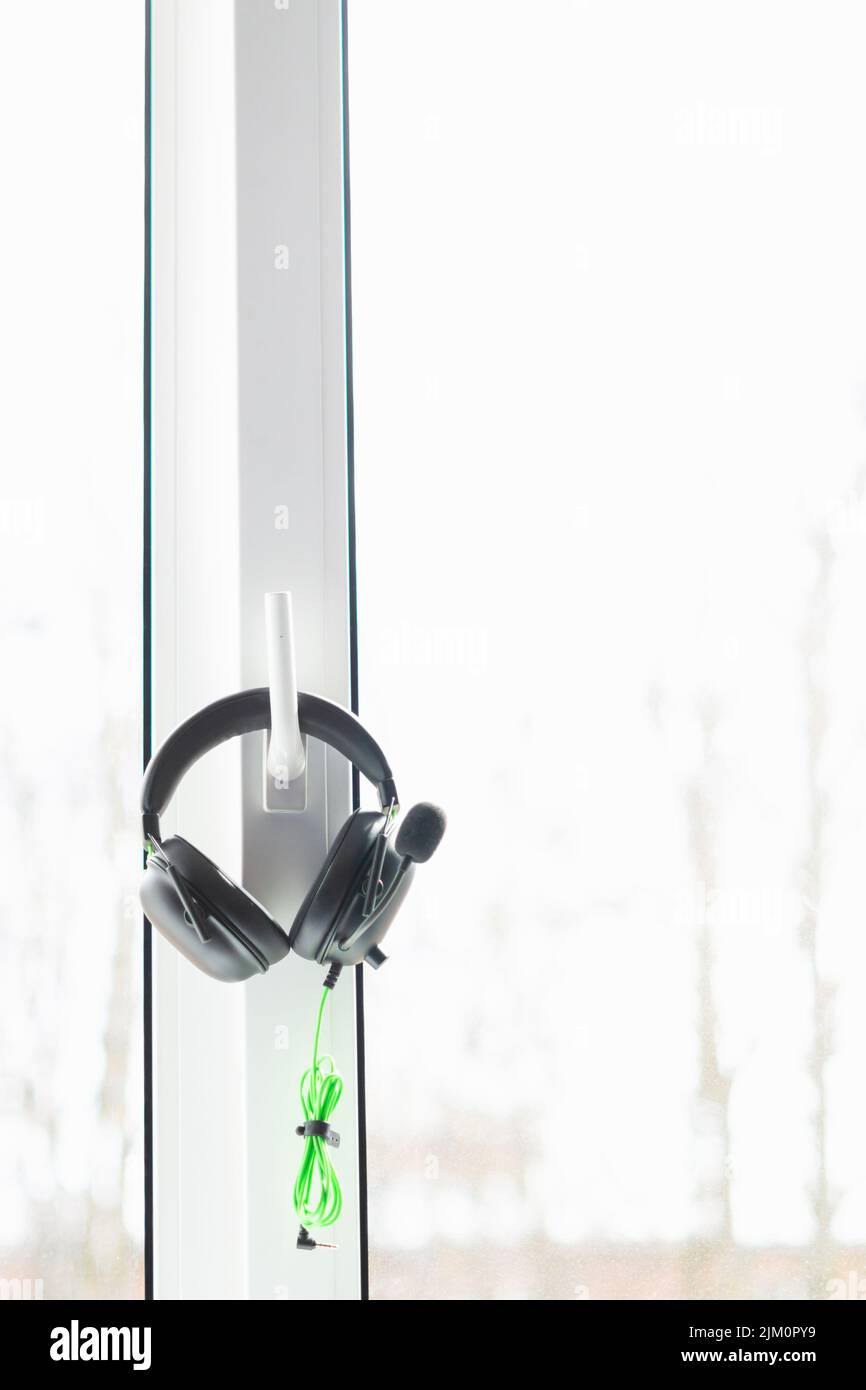 A closeup of headphones hanging on the window Stock Photo - Alamy