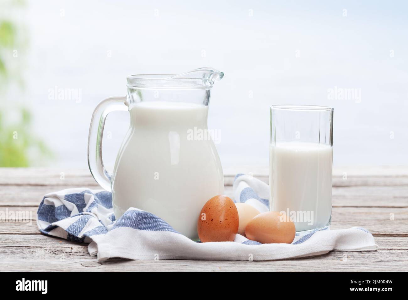 Milk in pitcher on garden wooden table. Outdoor Stock Photo - Alamy