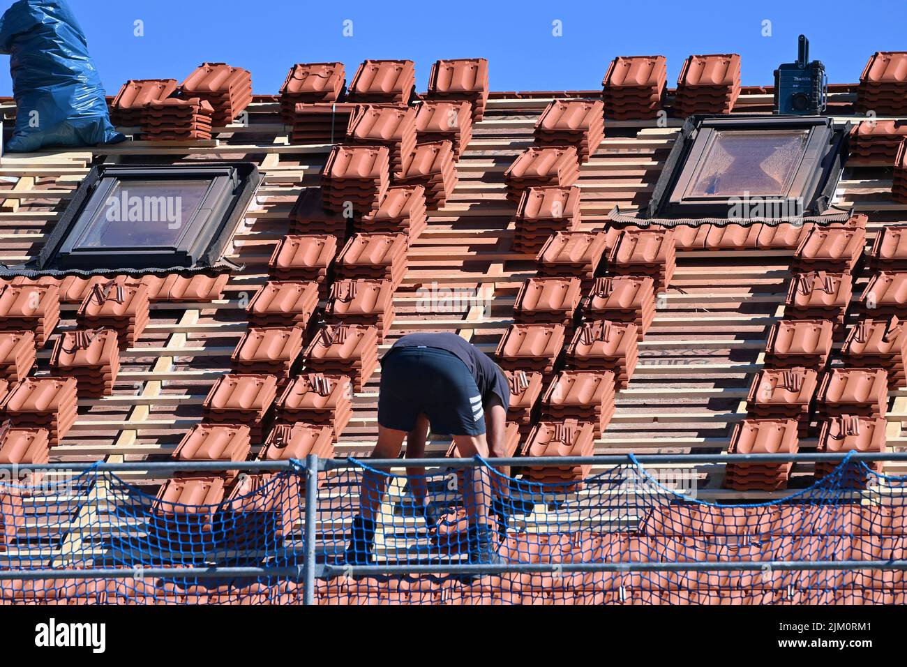 Warngau, Deutschland. 03rd Aug, 2022. Roofer at work on a house in hot ...