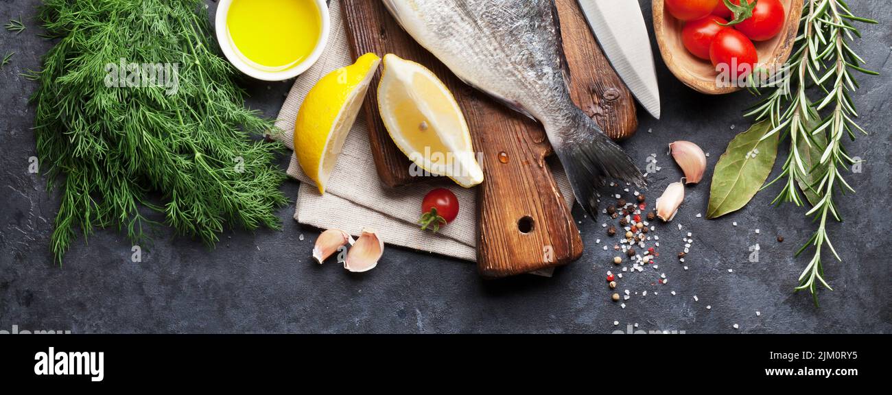 Raw fish cooking and ingredients. Dorado, lemon, herbs and spices. Flat ...