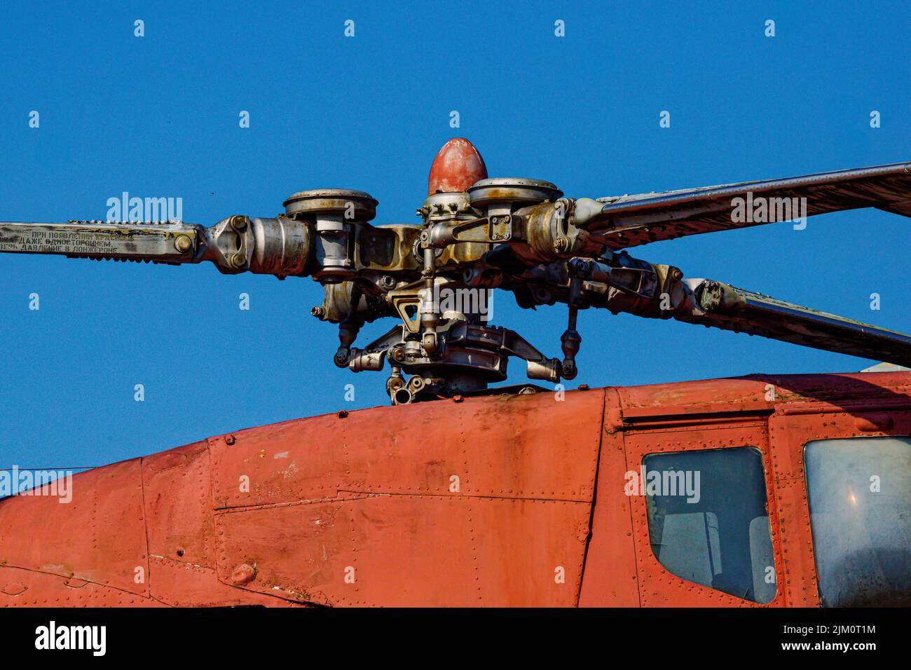 A closeup of rusted old helicopter propellers with a clear blue sky in ...
