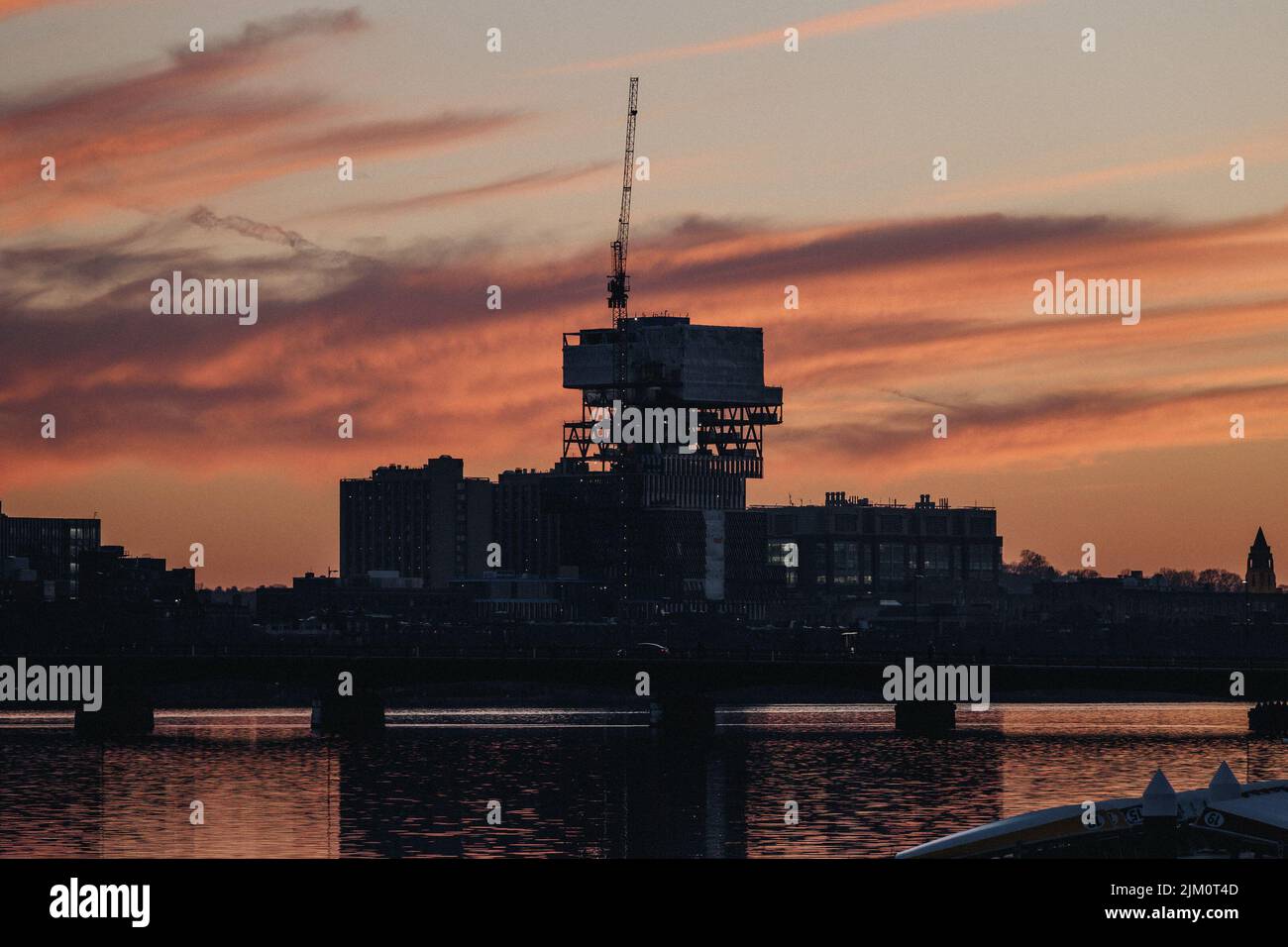 A beautiful vibrant orangey-red sunset over buildings with construction ...