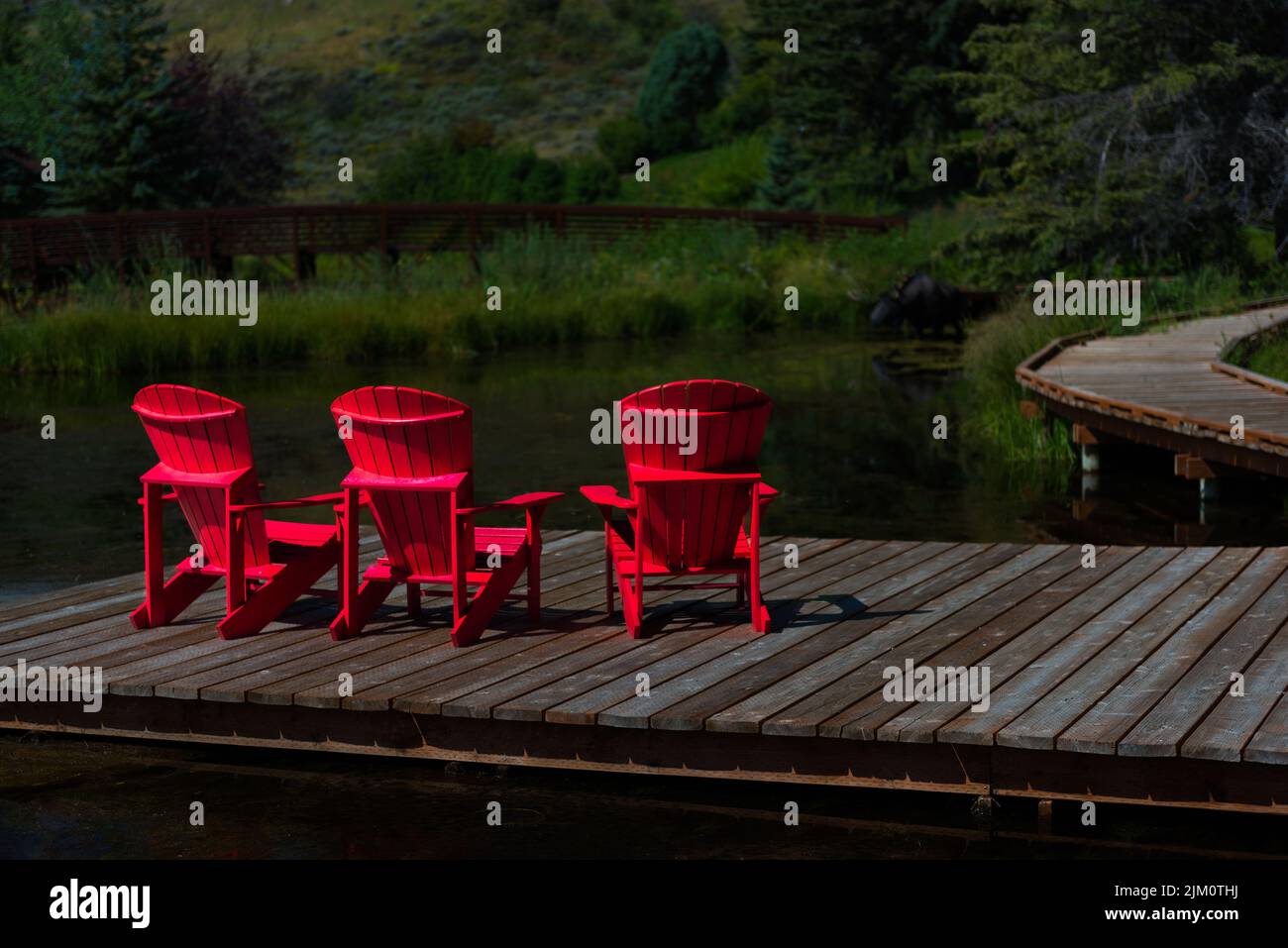 Red outdoor chairs by a lake with a mountain as a backdrop in Jackson ...