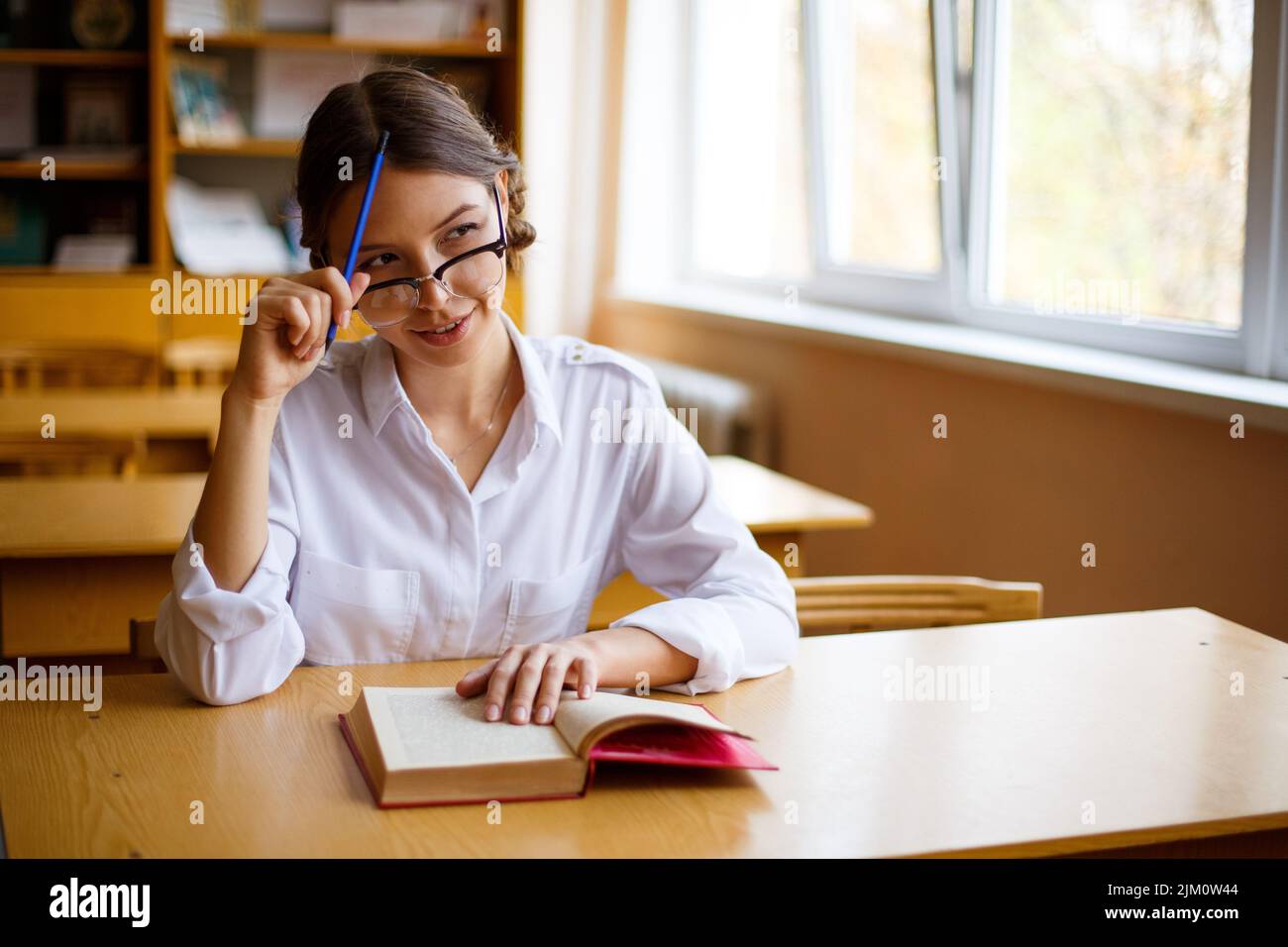 Focused millennial female student sits in classroom studying with ...