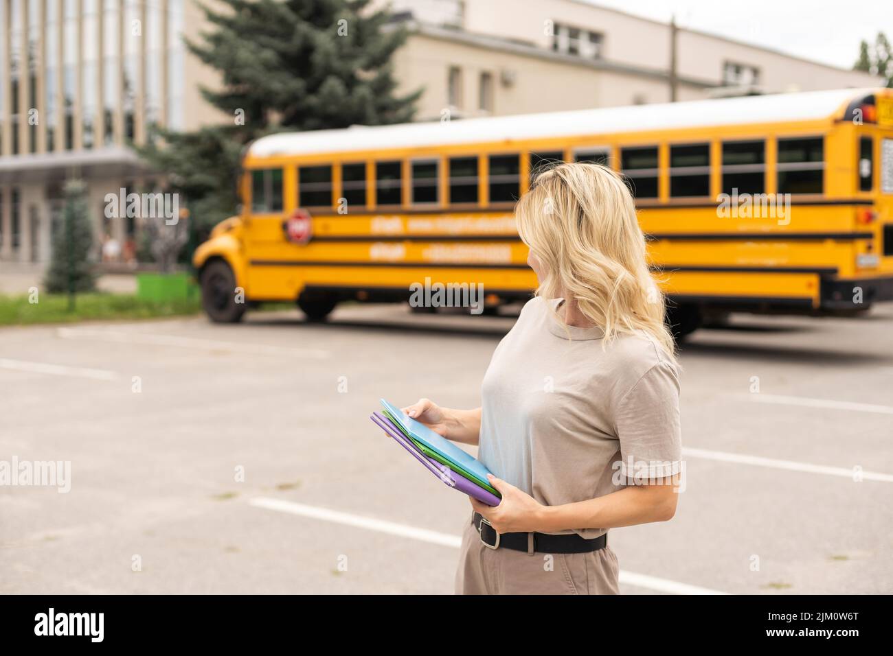 Teacher of elementary school near the school bus Stock Photo - Alamy